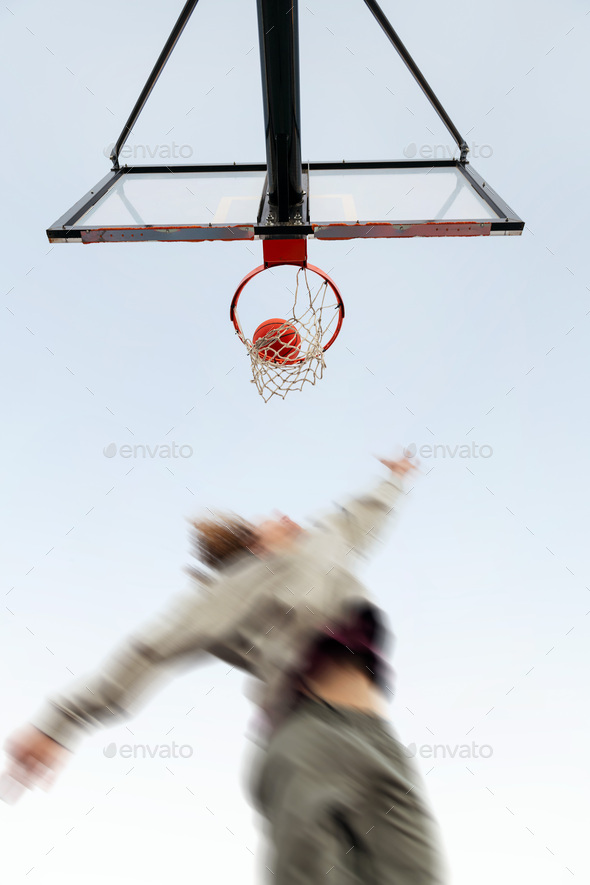 man shooting a basket in a basketball court Stock Photo by Raul_Mellado