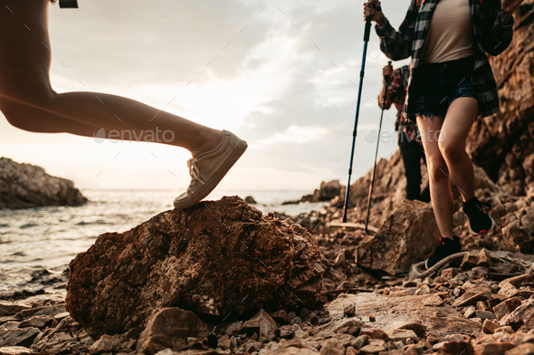 Hikers walking on the rocks in the middle of the sea.Teamwork and ...