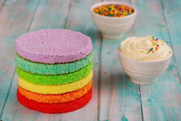 Cake assembly. layer cake with white icing and sprinkles. Stock Photo ...