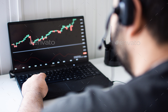 Man looking at a chart on a laptop Stock Photo by mary_8405 | PhotoDune