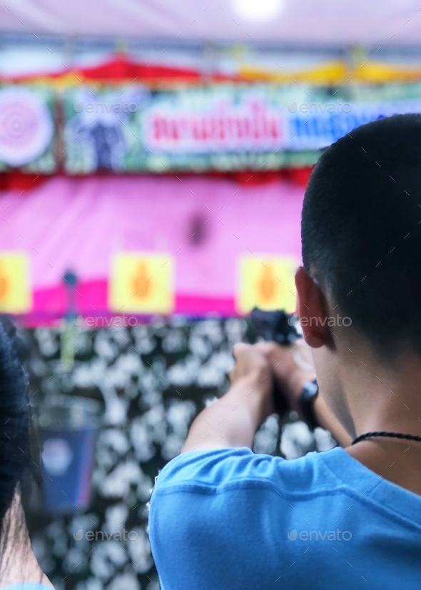Teenager having fun shooting target in carnival blur background Stock ...