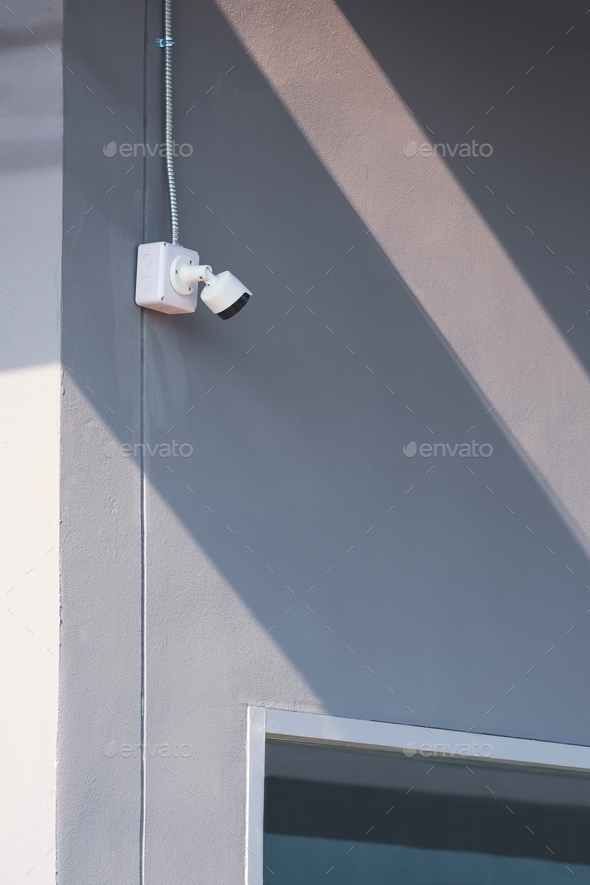 security camera and flexible metal conduit with part of glass window on ...