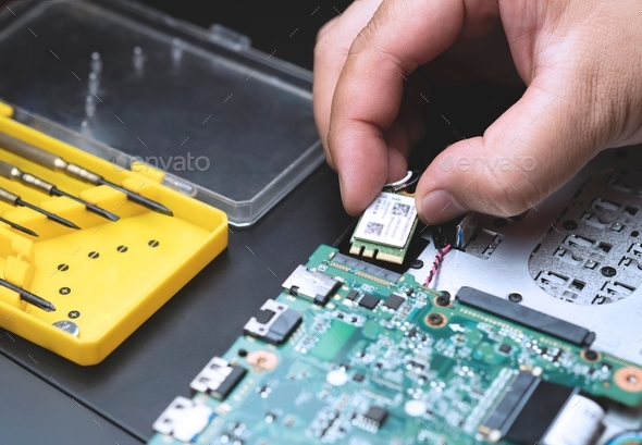 Technician's hand holding computer chip for install on electronic ...