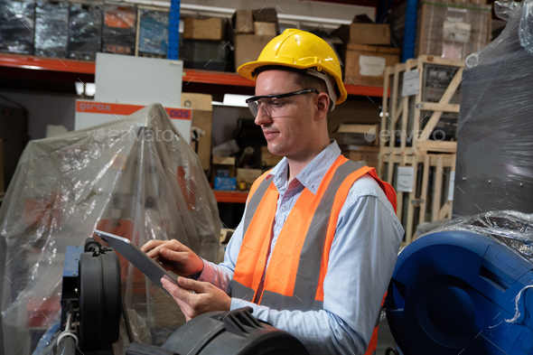 Engineer in warehouse use tablet check spare parts inventory check in ...