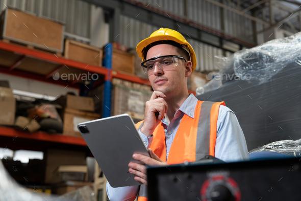 Engineer in warehouse use tablet check spare parts inventory check in ...