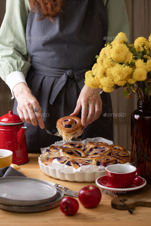 girl in an apron girl laying out cinnabon buns Stock Photo by azgek