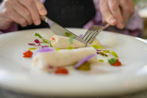 male hands holding a knife and fork eating a modern plate of food Stock ...