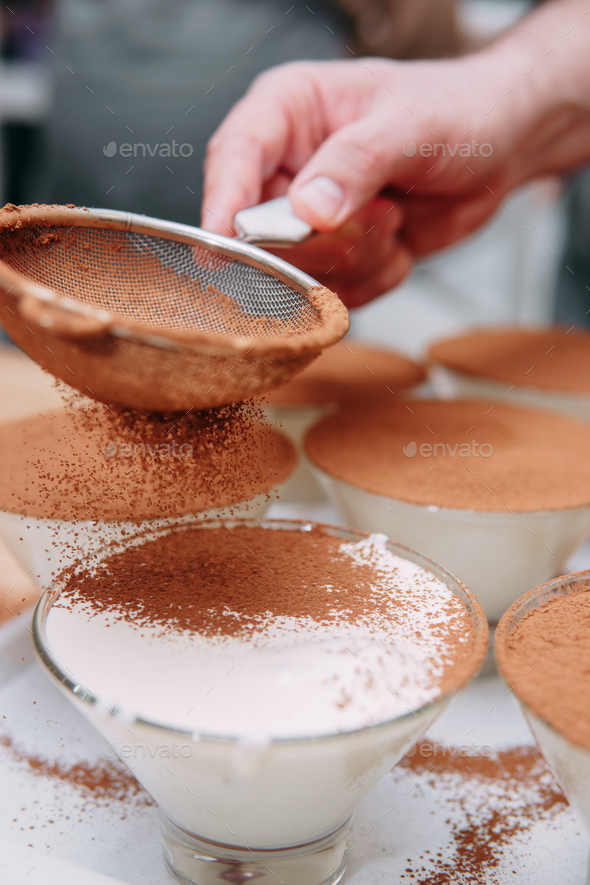 The Process of preparing tiramisu dessert. The dish is sprinkled with ...