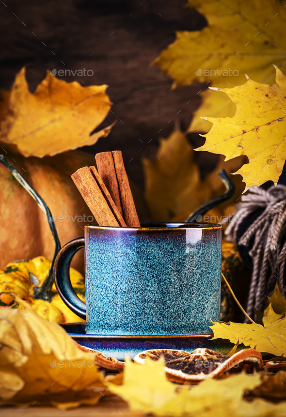 Autumn hot drink in blue cup on fall background with pumpkins, fallen ...