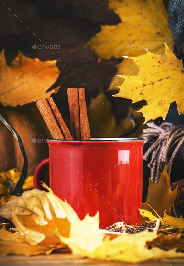 Autumn hot drink in red cup on fall background with pumpkins, fallen ...