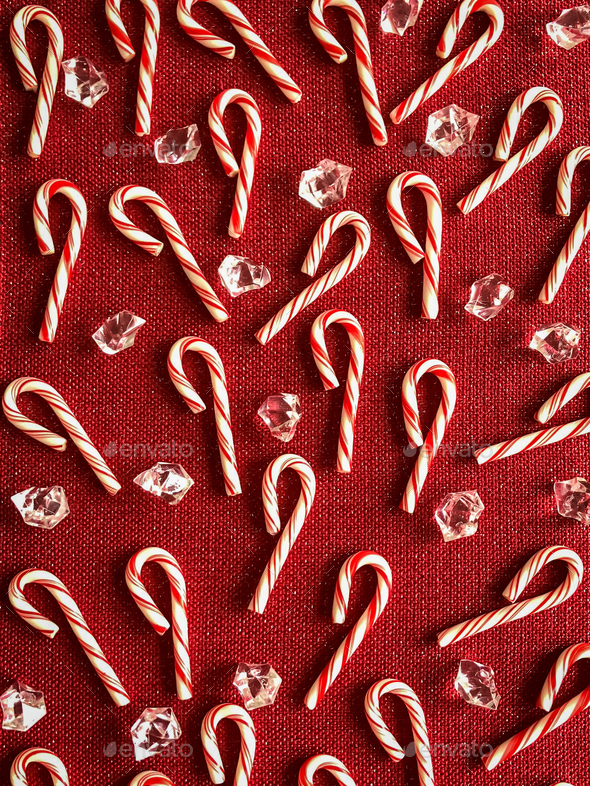 Christmas flat lay with patterned candy canes on red textured surface ...