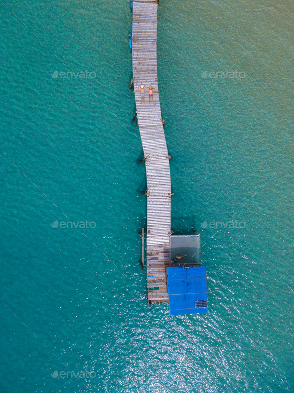 Drone aerial view at wooden pier with men and women on the pier from ...