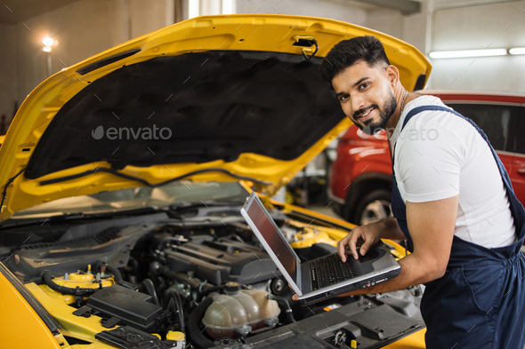 Engineer young man looking at inspection vehicle details under car hood ...