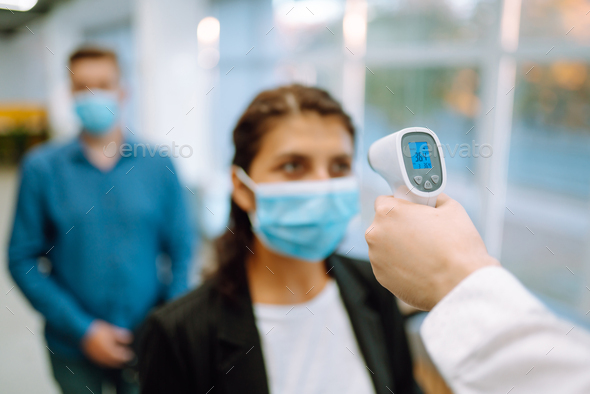 Office staff undergo temperature screening at the entrance. Business ...