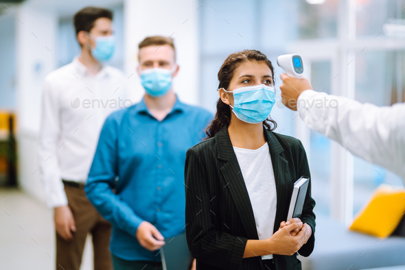 Office staff undergo temperature screening at the entrance. Business ...