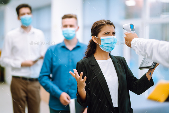 Office staff undergo temperature screening at the entrance. Business ...