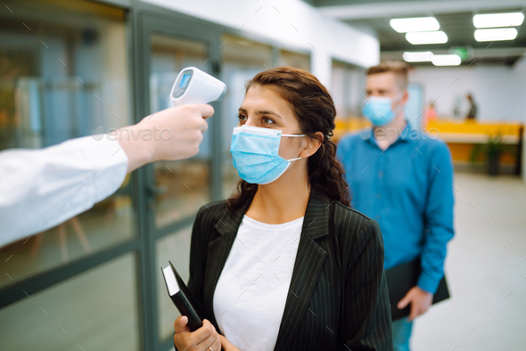 Office staff undergo temperature screening at the entrance. Business ...