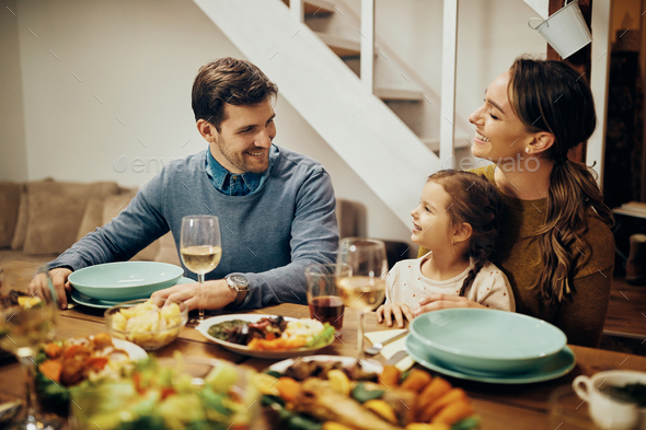 Happy family talking while eating lunch at dining table. Stock Photo by ...