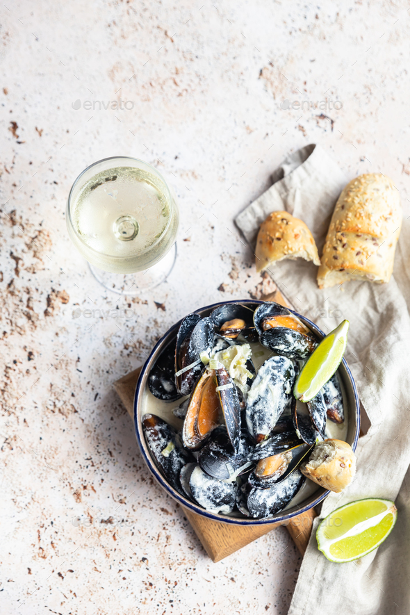 Blue mussels in creamy white wine sauce with lime and bread Stock Photo ...