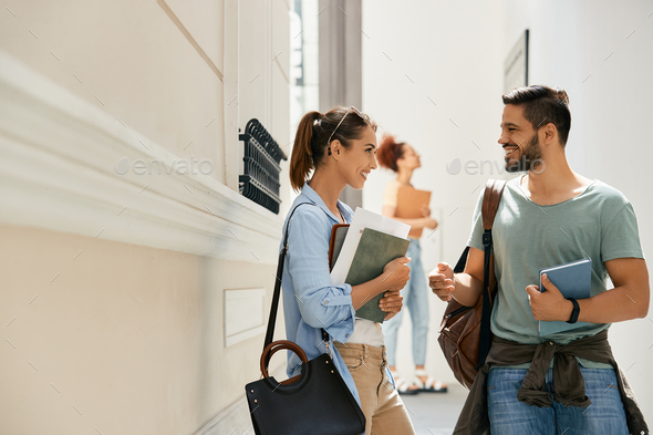 Happy college student communicating with her friend in a hallway. Stock ...