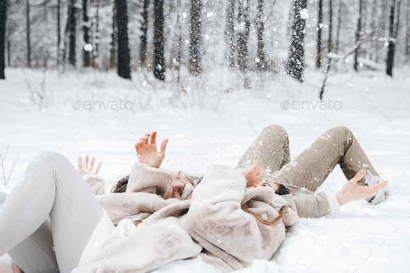 Romantic snow love story.Young couple guy girl lying,playing in snowy ...