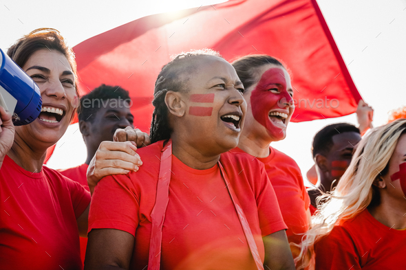 Multiracial red sport football fans celebrate team victory in ...