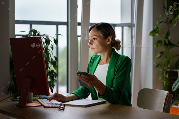 Successful Caucasian woman manager in green business suit works at ...