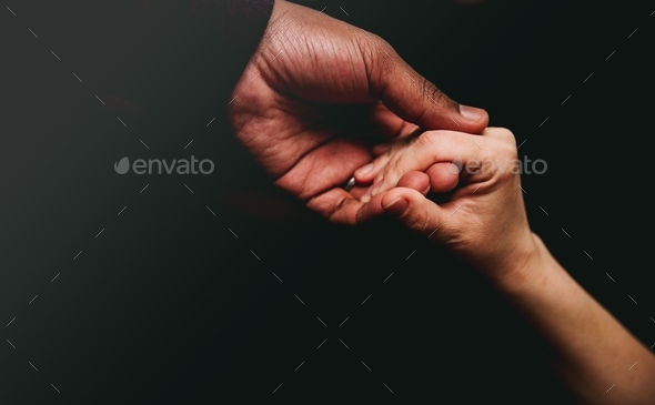 A black male hand reaching down for a white female hand to lift her up ...