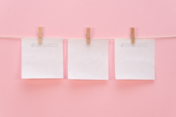 three clean empty white stickers hanging with a clothespin on a rope on ...