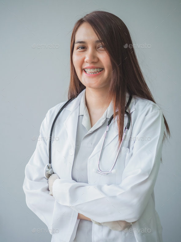 Professional female nurse or doctor with stethoscope, cross arms chest ...