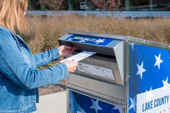 A woman is safely and securely mailing her ballot at an official ...