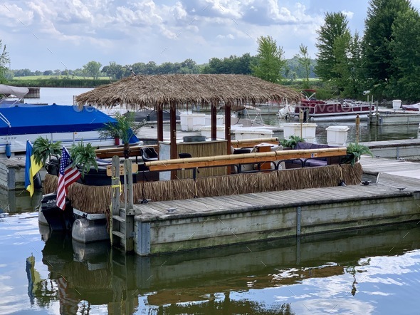 Tiki bar pontoon boat on the river on a summer day Stock Photo by krisprahl