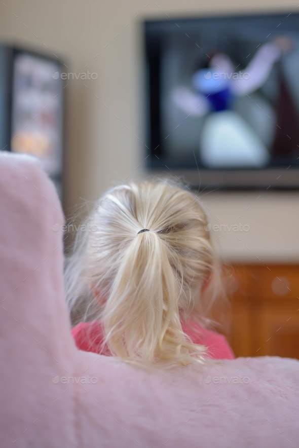 Back view of little blonde girl watching a movie on tv Stock Photo by ...