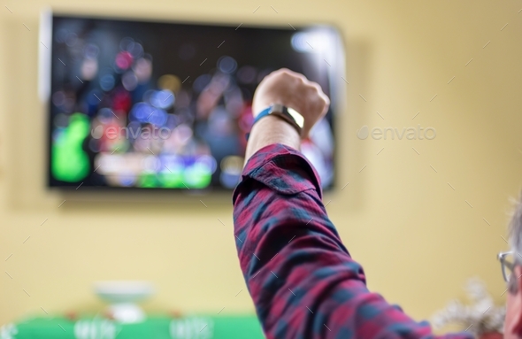Man watching tv cheering for his team Stock Photo by krisprahl | PhotoDune