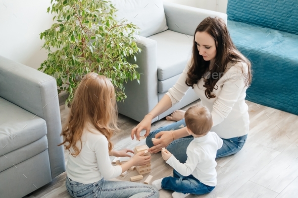 mom and kids playing django game on the floor Stock Photo by Repnitskaya