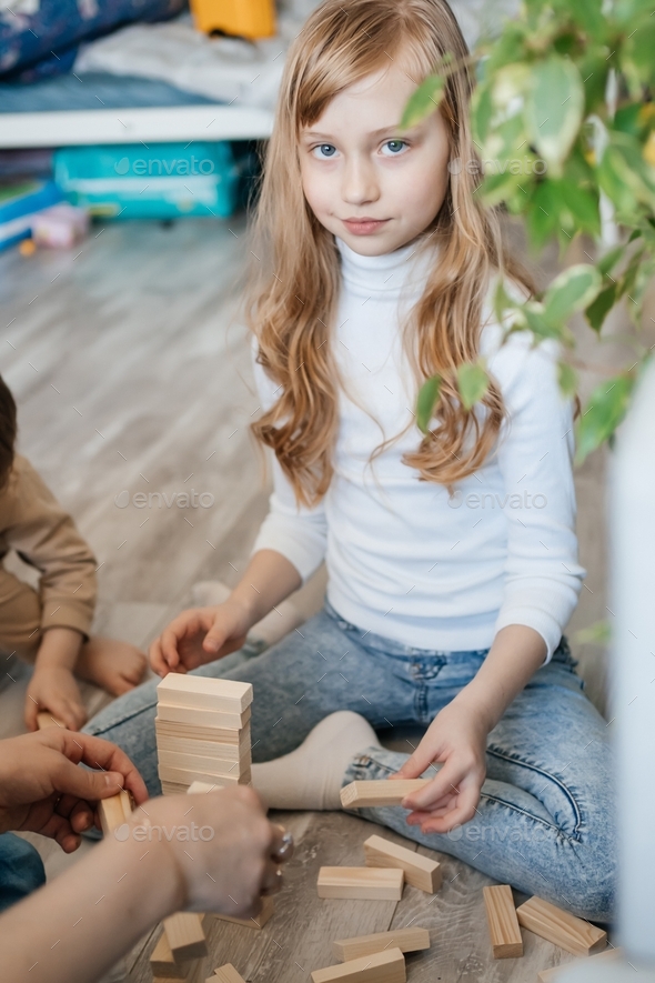 girl plays a game of django with her family on the floor Stock Photo by ...
