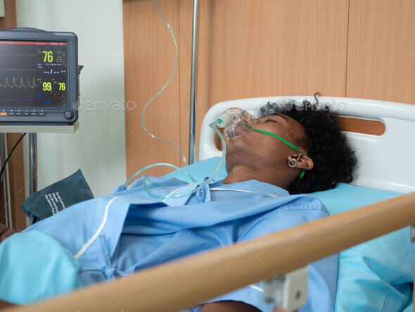 At hospital intensive care unit patient in coma lay on bed ...