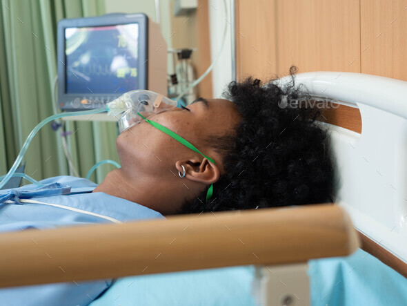 At hospital intensive care unit patient in coma lay on bed ...