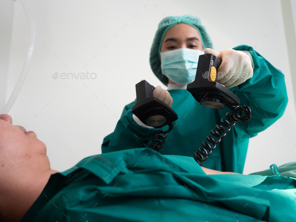 In hospital emergency room doctor shocking the heart use defibrillator ...