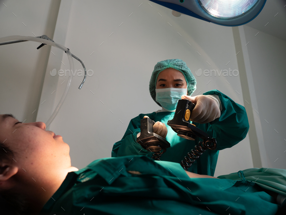 In hospital emergency room doctor shocking the heart use defibrillator ...