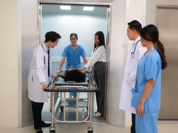 At hospital doctor and nurse looking at medical team in elevator ...