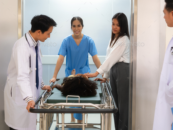 At hospital doctor and nurse looking at medical team in elevator ...