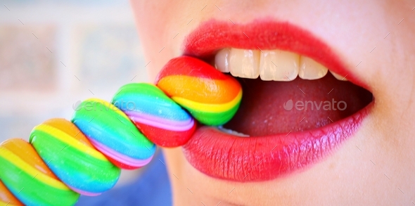 Mouth with pink lips and straight teeth taking a bite of swirly rainbow ...