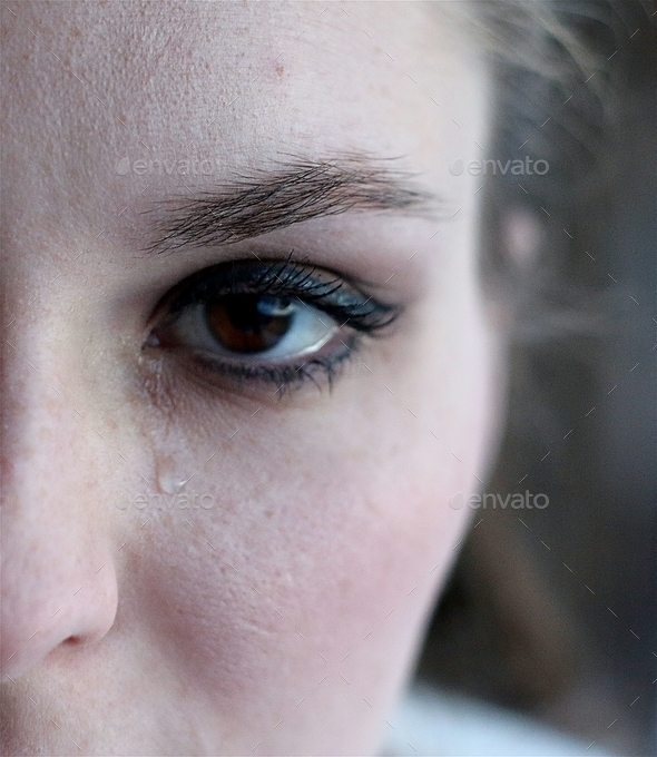 Vertical minimalist image of a female with a teardrop falling from from ...