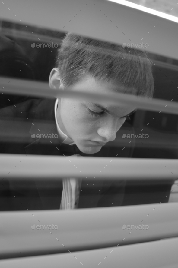 Vertical monochromatic image of boy wearing a tux as seen through ...