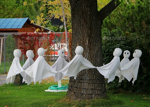 Halloween yard decorations of white ghosts dancing around a tree. Stock ...