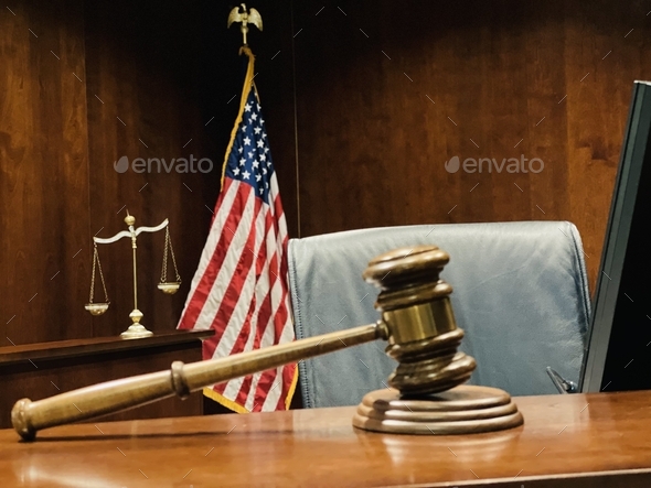 Judge’s wooden gavel on judicial bench, scales of justice and flag of ...