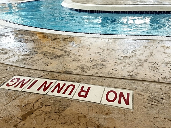 No Running warning on the ground at an indoor swimming pool. Stock ...