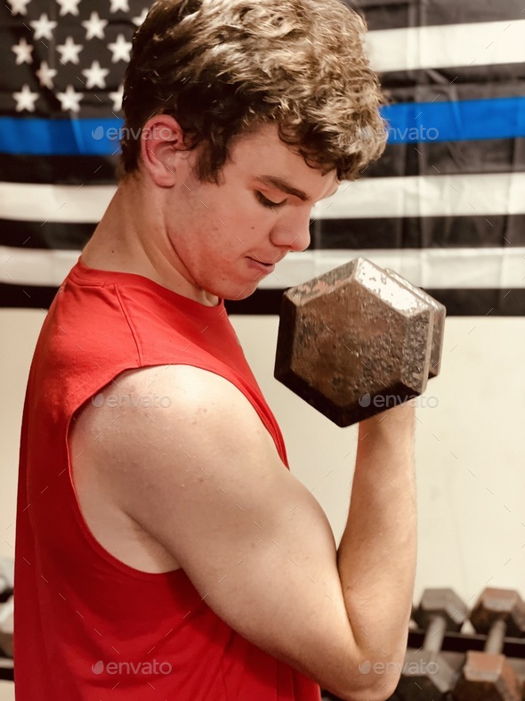 Gen Z working out in gym doing reps of dumbbell bicep curls Stock Photo ...