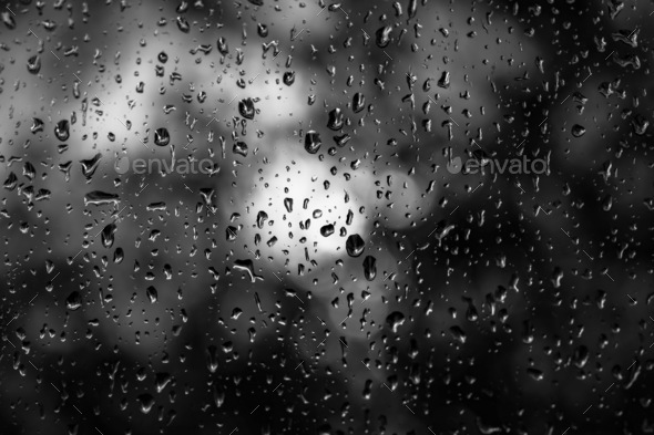 Dark and moody look through a raindrop covered window in black and ...